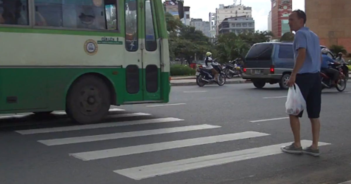Man plays real-life game of "Frogger" to cross the street - CBS News