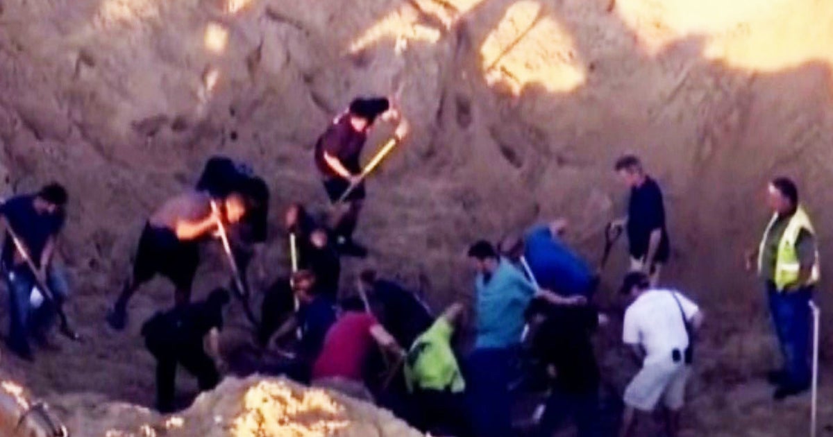 Boy rescued after hours trapped under sand dune - CBS News