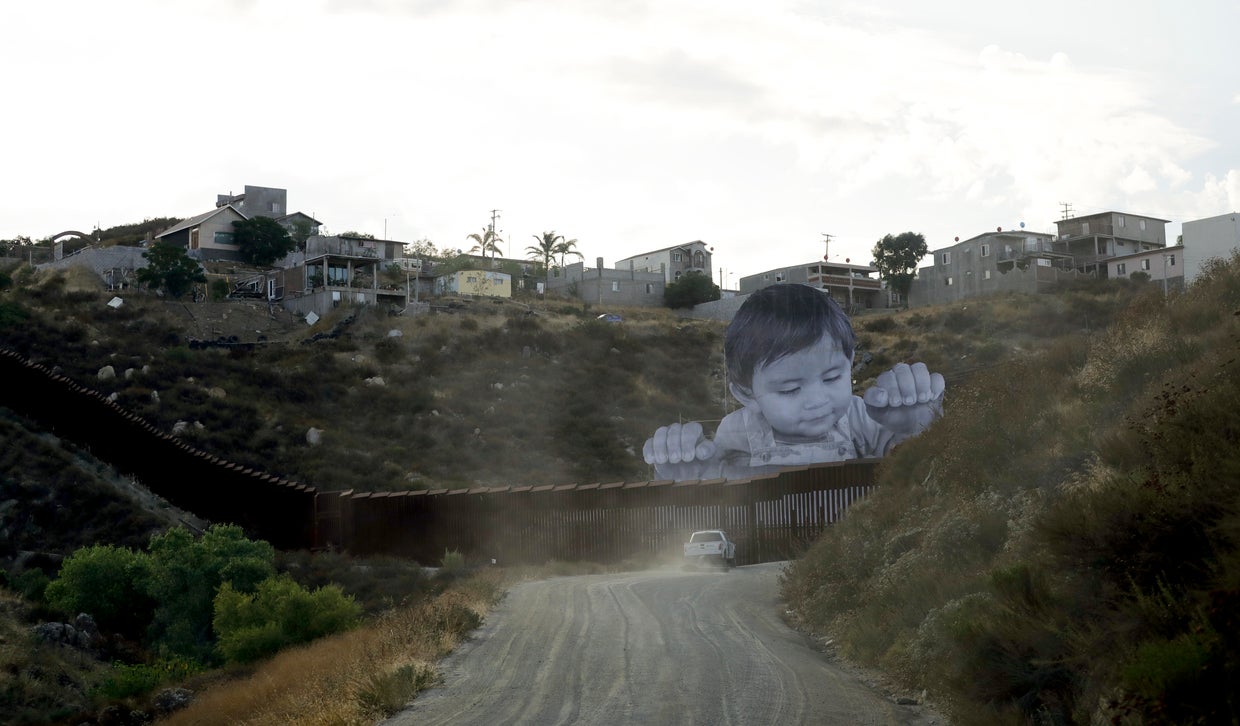 Massive portrait shows toddler peering over U.S.-Mexico border - CBS News