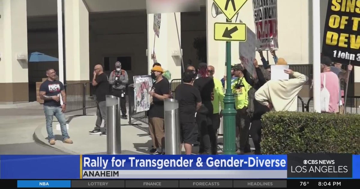 Dozens gather at rally for transgender and gender-diverse comprehensive ...