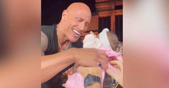 Baby crowd-surfs to The Rock - CBS News