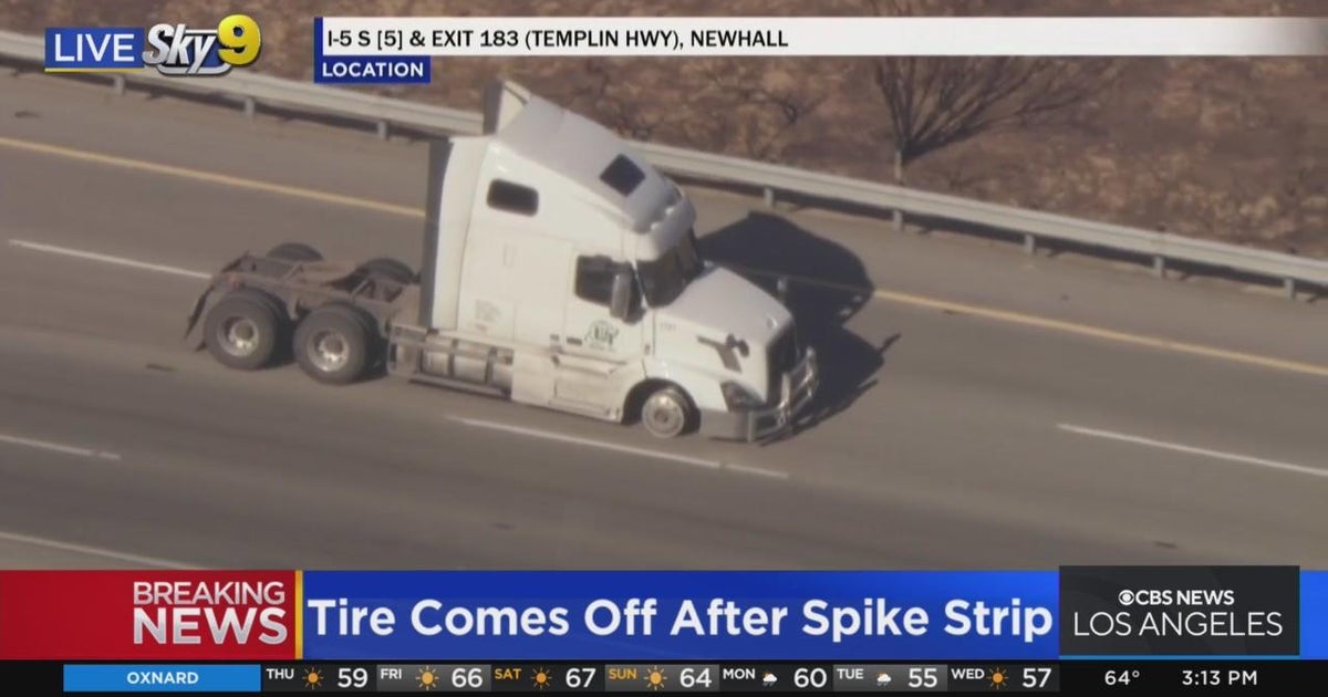 Front tire comes off big rig after spike strip - CBS Los Angeles