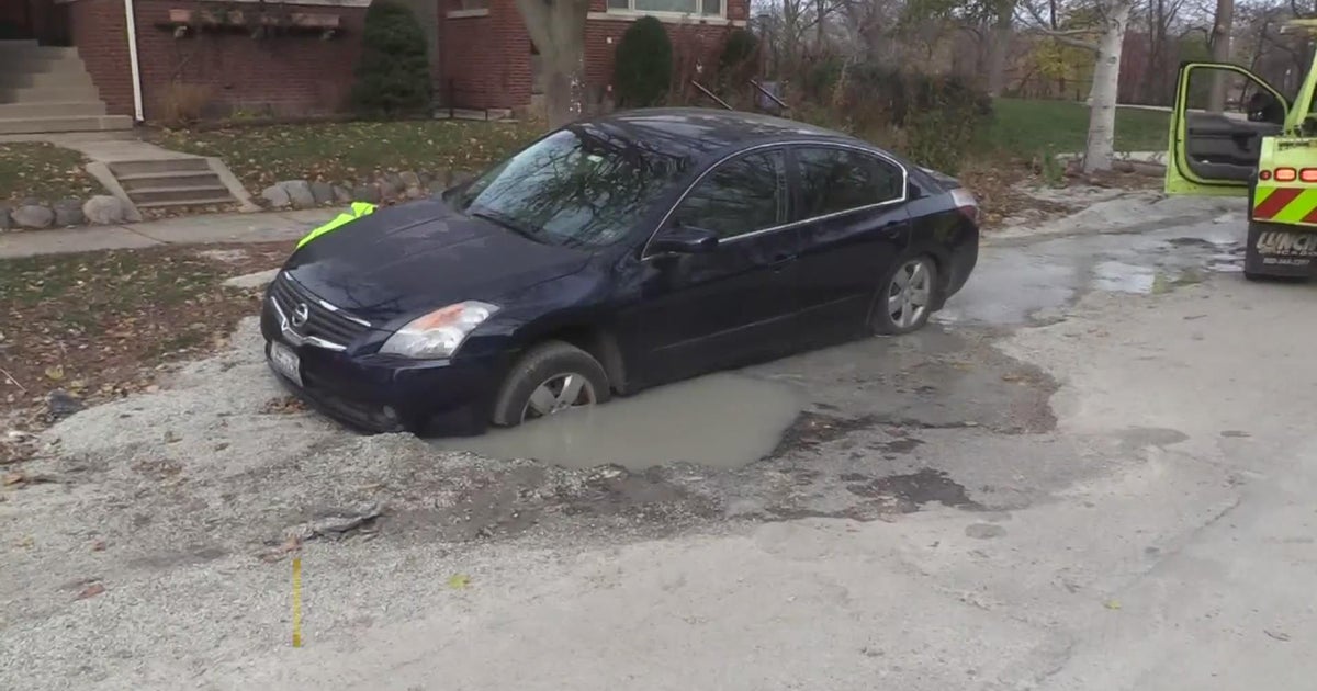 Car in Albany Park partially swallowed by sinkhole - CBS Chicago
