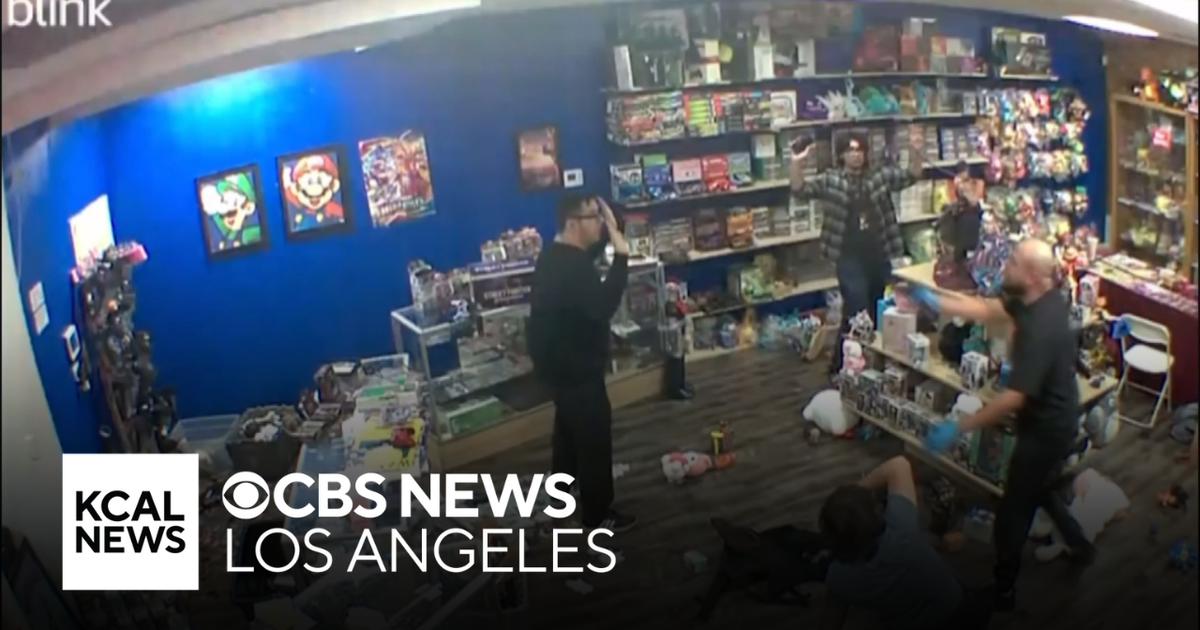 Security camera shows suspect robbing gaming store at gunpoint - CBS ...